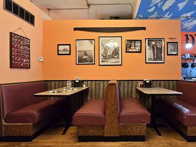 Cozy booth seating against orange walls creates the perfect spot for lingering over lunch and good company.