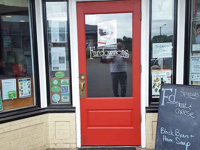 The bright red entrance door pops against the storefront like a lipstick kiss, impossible to miss or resist.