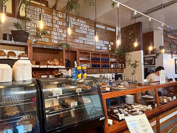 The counter area displays pastries like edible art, with that coffee menu board promising caffeinated happiness for all.