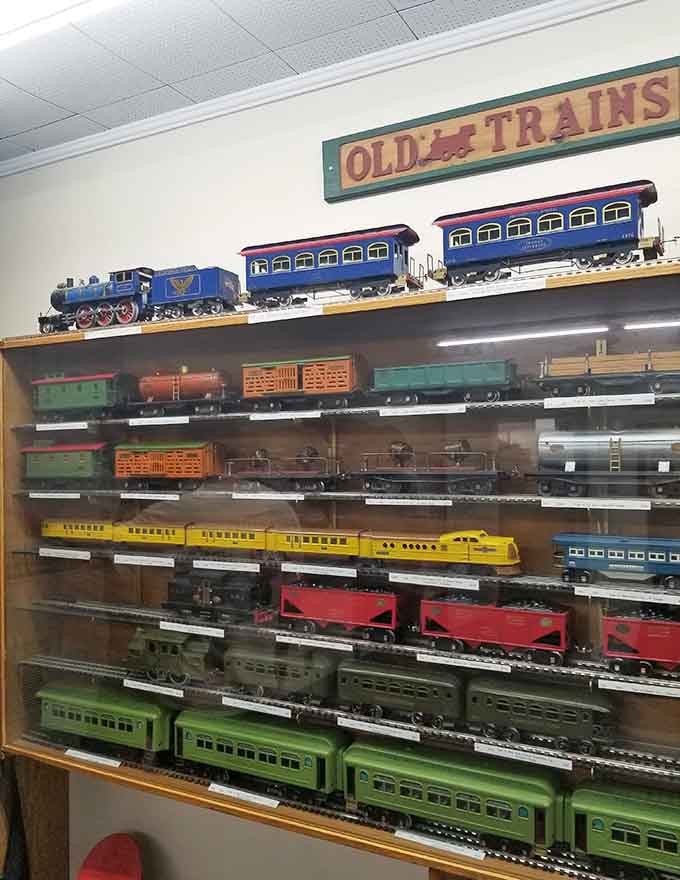 Shelves of classic toy trains await their next adventure, making grown men suddenly remember their childhood Christmas wishes vividly.