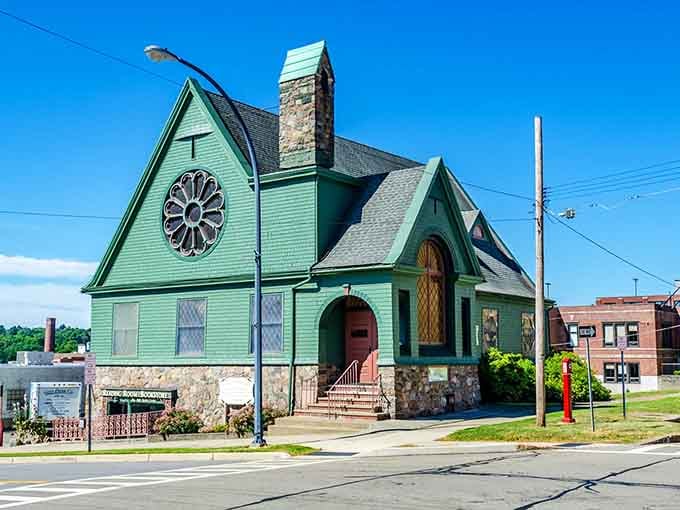 The green church with its rose window is giving serious fairy tale cottage energy mixed with Gothic Revival charm.