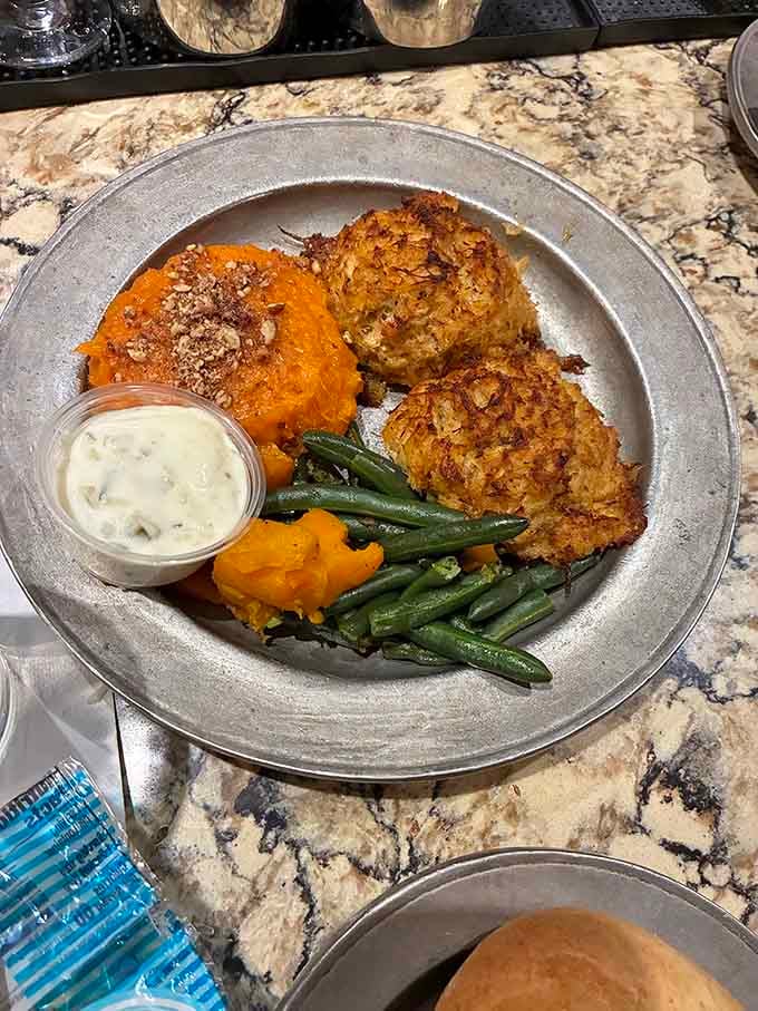 Golden crab cakes with green beans and butternut squash, plated like they actually care how your dinner looks.