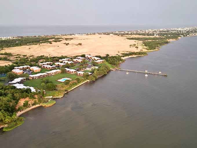 Aerial perspective reveals how the dunes nestle between sound and civilization, a sandy oasis in the Outer Banks landscape.
