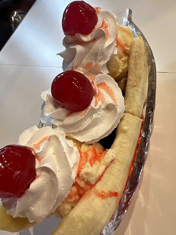 A banana split with whipped cream peaks and cherries, proving that three scoops are better than one.