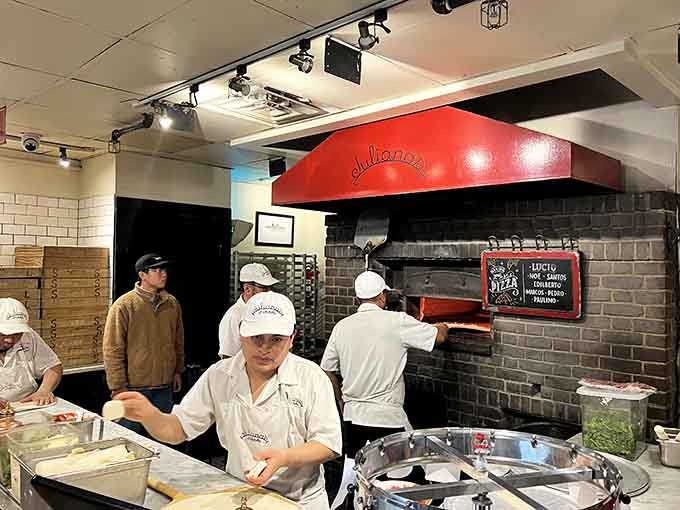 The coal oven glows red-hot while skilled hands orchestrate the ancient dance of dough and fire.