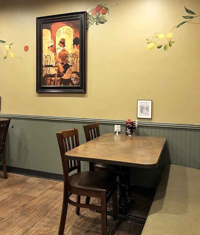 That vintage cafe artwork on butter-yellow walls creates an atmosphere warmer than your grandmother's kitchen on Sunday morning.