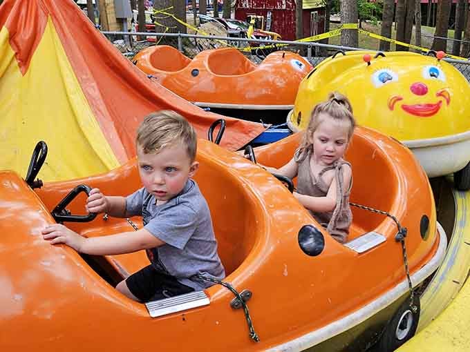 Kiddie rides with smiling faces deliver pure joy without the stomach-dropping intensity of modern mega-coasters.