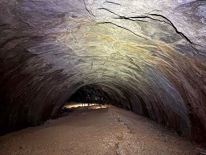 The smooth tunnel walls showcase the flowing patterns of ancient lava, frozen in time like geological fingerprints.