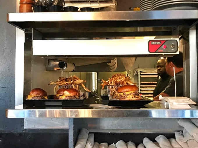 Behind the scenes, burgers sizzle under heat lamps, ready to deliver that perfect juicy bite you've been craving.