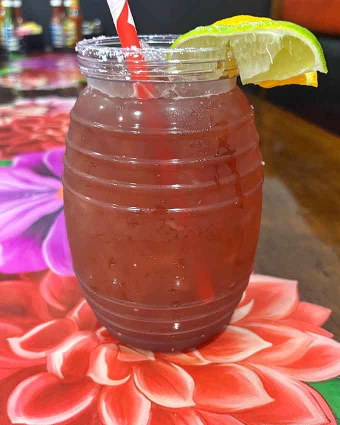 This refreshing drink in a barrel glass looks like summer vacation decided to show up in liquid form with a lime wedge.