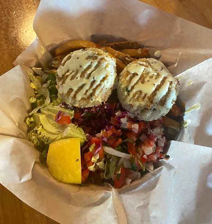 Crab cakes perched on a bed of vegetables like they're posing for their own cooking show.