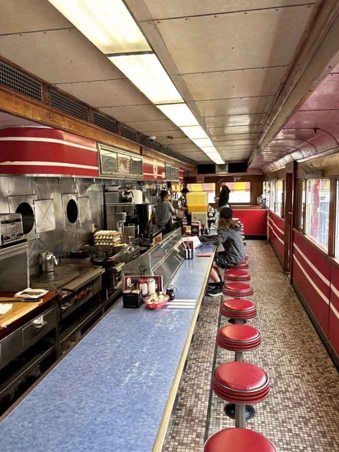 The view from these red vinyl stools includes sizzling griddles, flying spatulas, and breakfast magic in real time.