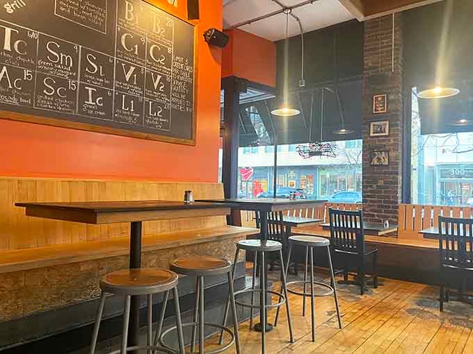 Sunlight streams through tall windows onto worn wooden floors where locals gather for conversation, cold drinks, and classic eats.