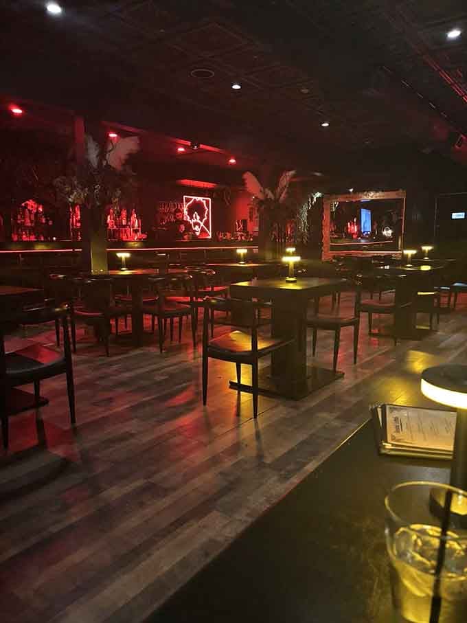 Red lighting bathes the dining room, creating an ambiance that feels like dining inside a velvet jewel box.