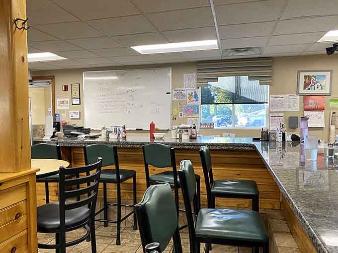 Counter seats offering front-row views of the breakfast ballet happening just beyond that well-worn service window.