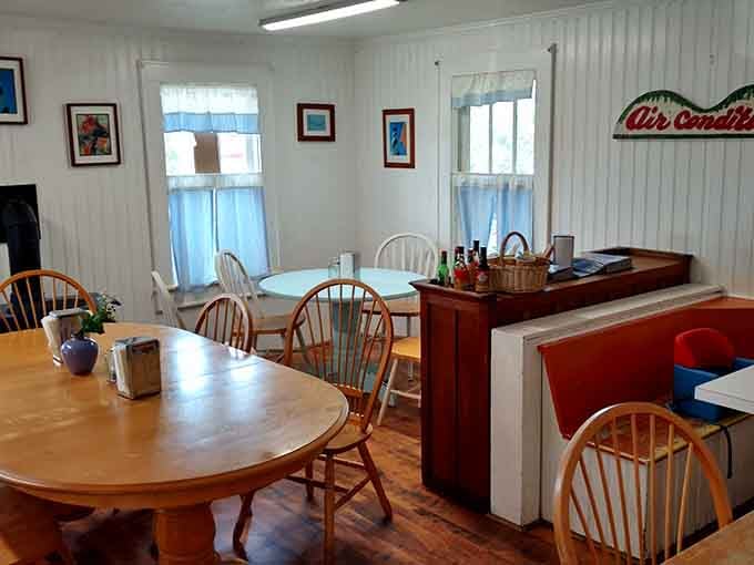 Sunlight streaming through cafe curtains onto wooden tables, this dining space feels like breakfast at grandma's beach house.