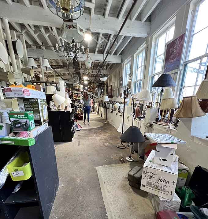 Lighting fixtures dangle overhead like an eclectic chandelier showroom, illuminating your path to the perfect lamp.