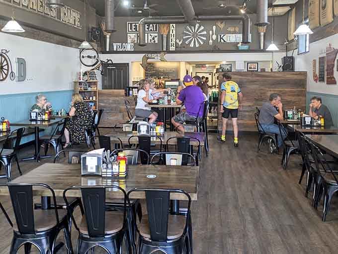 High ceilings and vintage signs create the kind of space where lingering over coffee feels mandatory rather than optional or rushed.