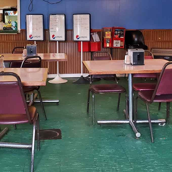 Classic diner seating with that green floor and wood paneling, where comfort matters more than Instagram aesthetics.