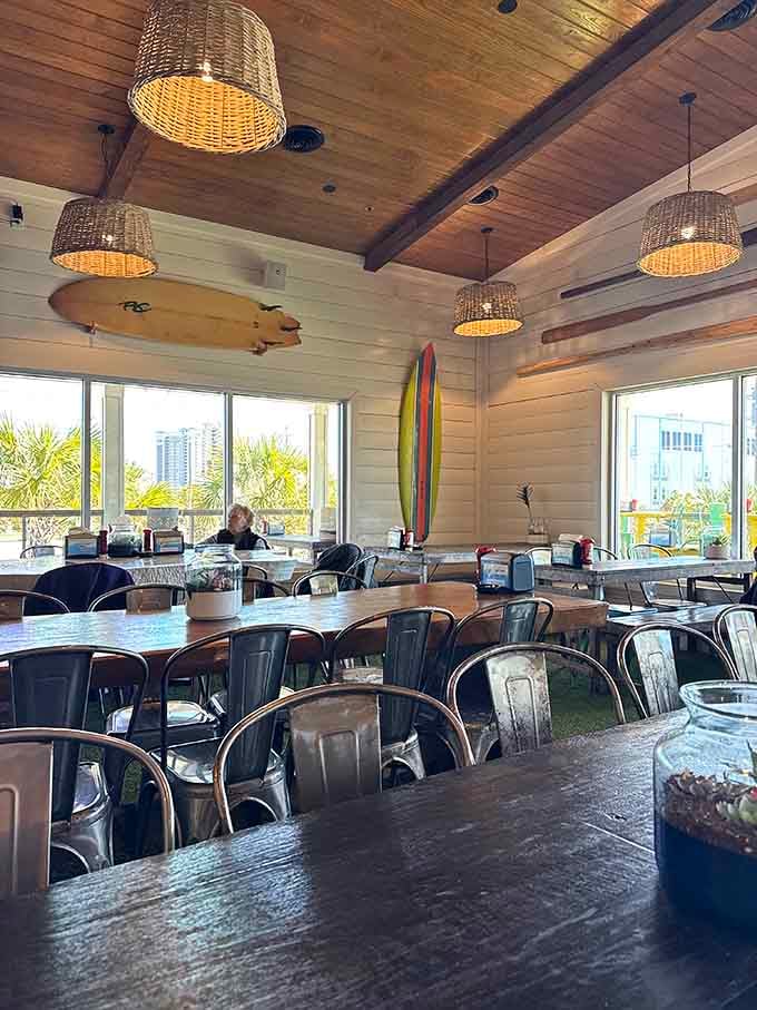 Indoor seating with those basket lights and surfboard decor, casual beach vibes without the sand in uncomfortable places.