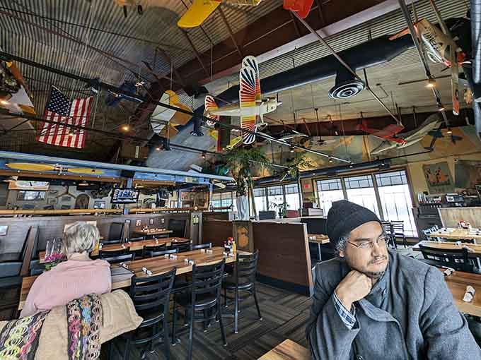 Dining beneath a canopy of vintage aircraft models transforms an ordinary meal into an immersive aviation experience.