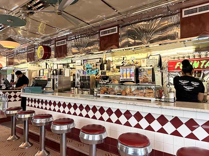 The counter stretches endlessly, lined with swivel stools and fronted by diamond-patterned tile that screams authentic diner style.