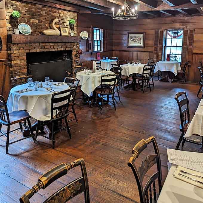 Wood floors and white tablecloths in a room with a fireplace, the kind of space that makes you sit up straighter.