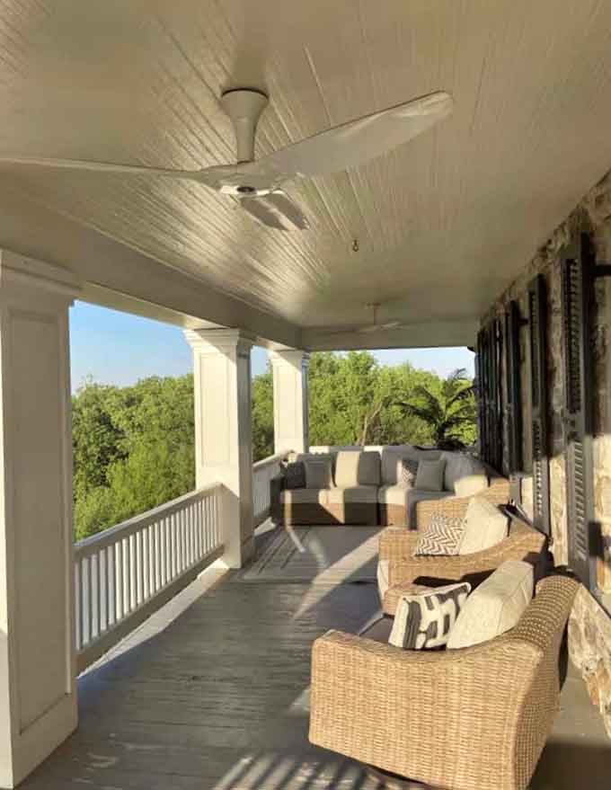 A porch that wraps around like it's giving the mansion a permanent hug, which honestly feels appropriate here.
