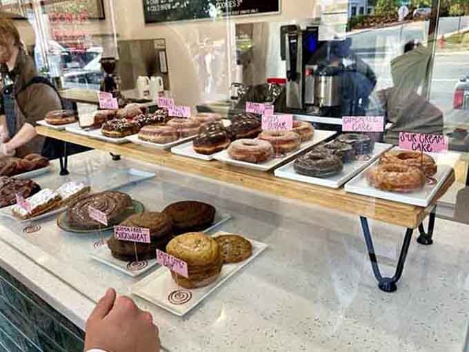 The display case showcasing fresh donuts on wooden boards is simple, beautiful, and utterly tempting.
