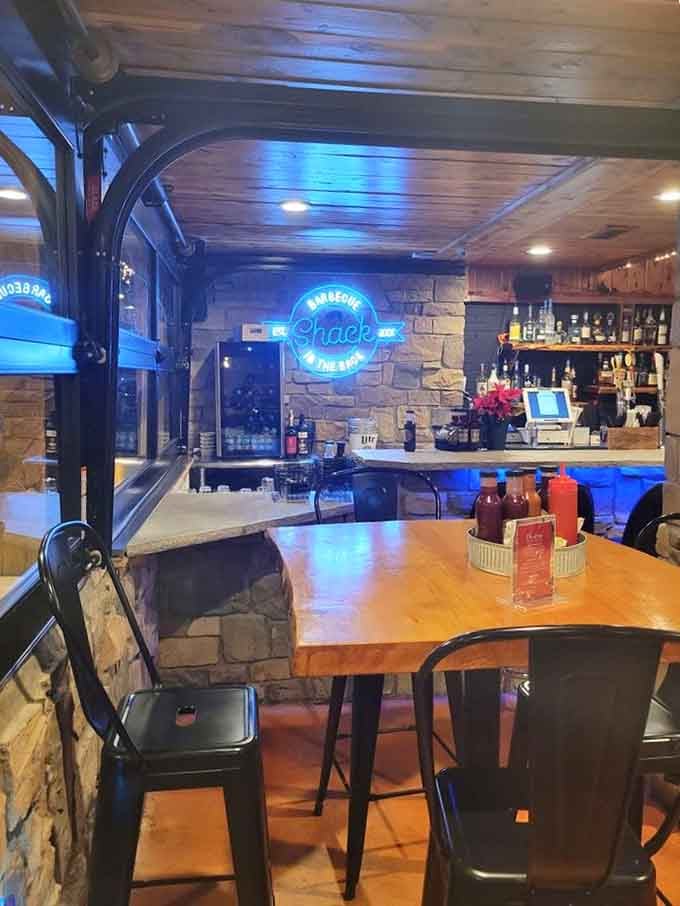 Stone accents and a full bar with that glowing sign create an unexpectedly upscale vibe for smoked meats.