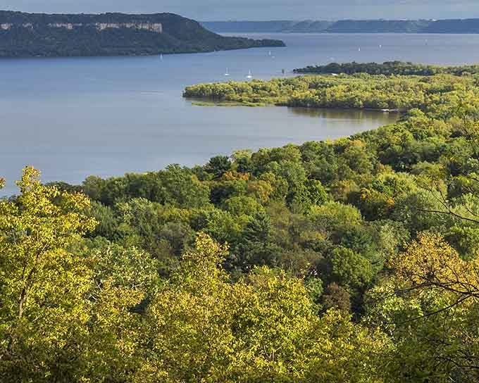 Lake Pepin stretches wide and peaceful below green bluffs, looking exactly like the postcard you'll definitely buy and actually mail.