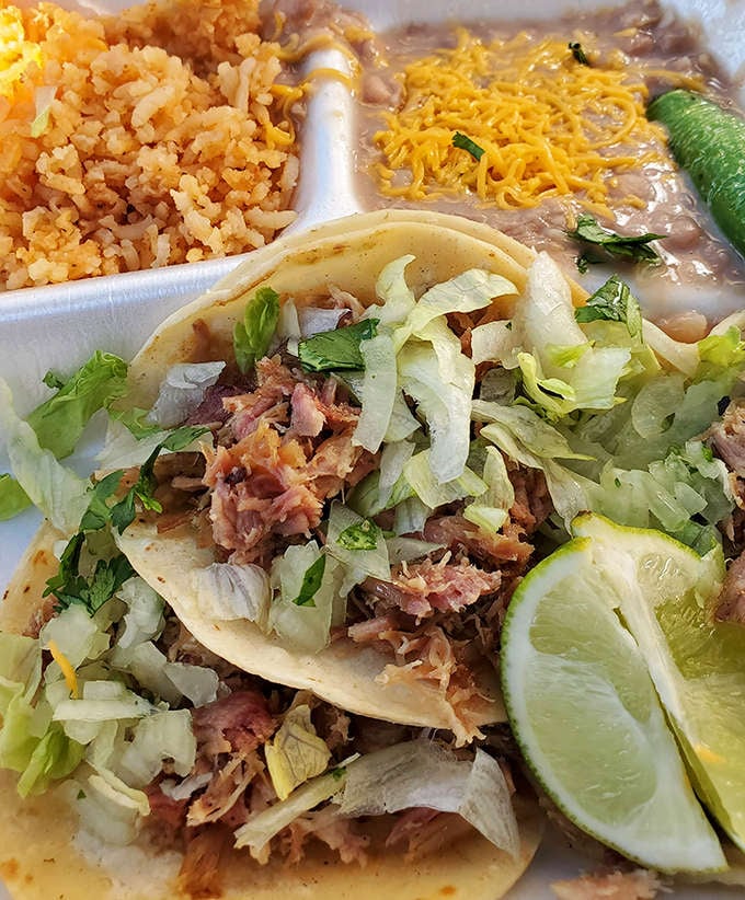 Carnitas tacos with fresh lettuce, lime wedges, rice and beans: simplicity executed to absolute perfection here.