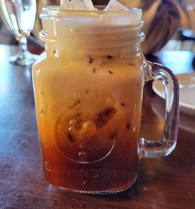 Thai iced tea served in a mason jar, because even traditional drinks deserve a little modern flair.