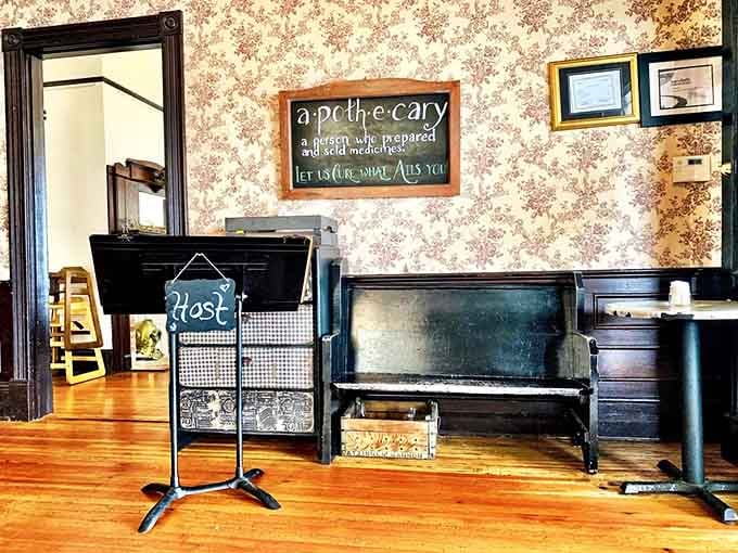 The host stand with vintage wallpaper and antique piano sets expectations high before you even see the menu.