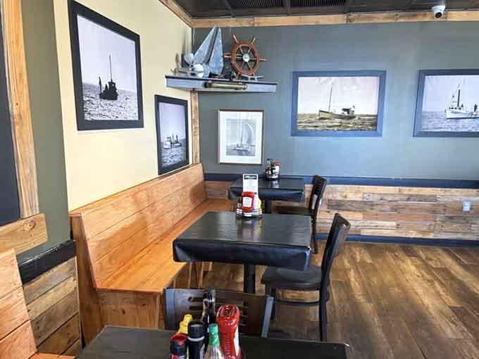 Ship's wheel and sailing photographs celebrate Hampton's maritime heritage without turning the dining room into a theme park attraction.