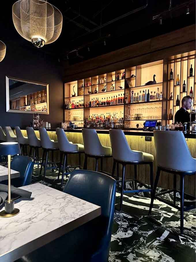 The backlit bar glows like a beacon of liquid creativity, promising handcrafted cocktails that'll redefine your expectations completely.