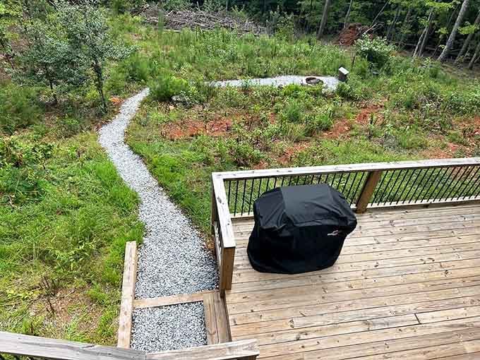 A gravel pathway winds through native landscaping, inviting exploration of the wooded property surrounding your camera house sanctuary.