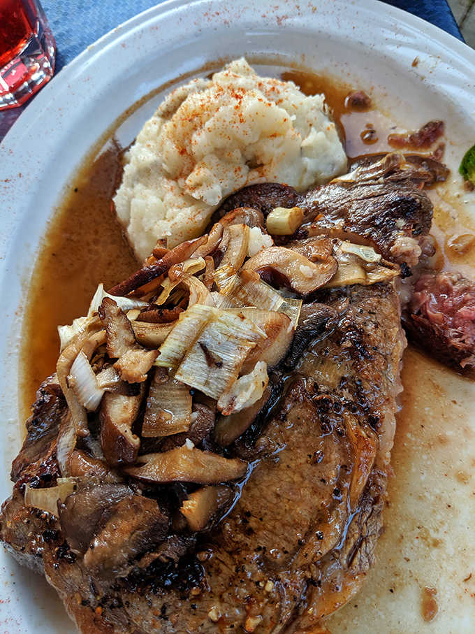 A perfectly cooked ribeye topped with caramelized onions, because sometimes even seafood restaurants know their way around beef.