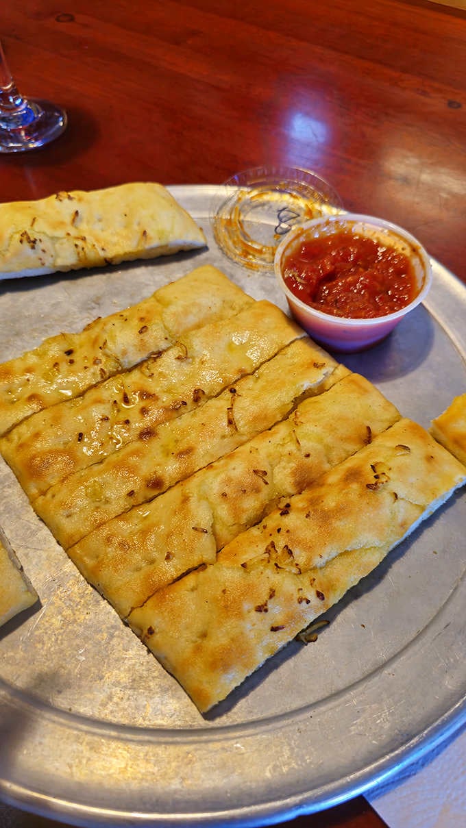 Golden breadsticks arrive warm and ready for dipping, the perfect supporting act to your main pizza event.