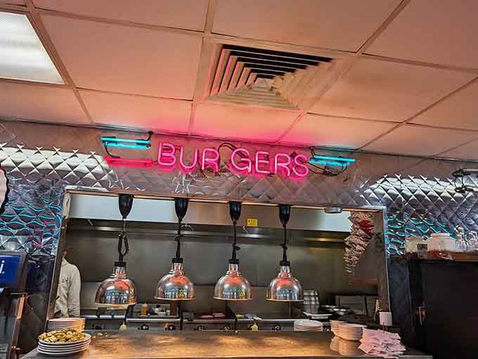 That neon "BURGERS" sign glowing above the kitchen isn't just decor; it's a promise being fulfilled with every sizzling patty.