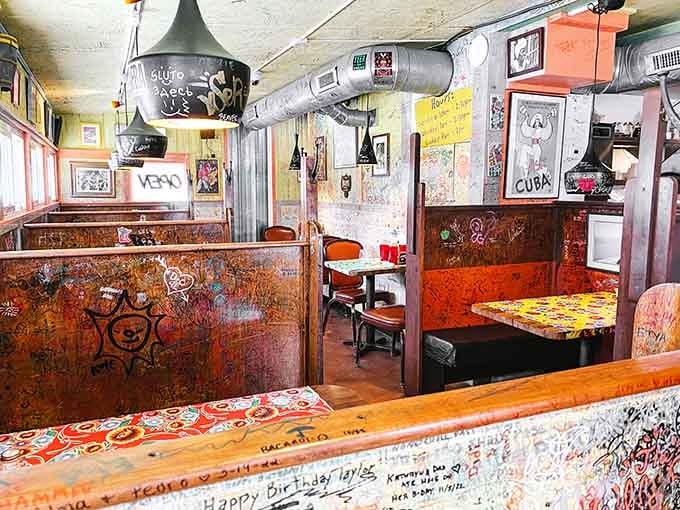 The signature-covered walls create an intimate dining room that feels like eating inside a beloved community scrapbook come alive.