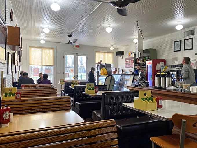 Wooden benches and natural light create a welcoming space where strangers become friends over exceptional sandwiches and conversation.