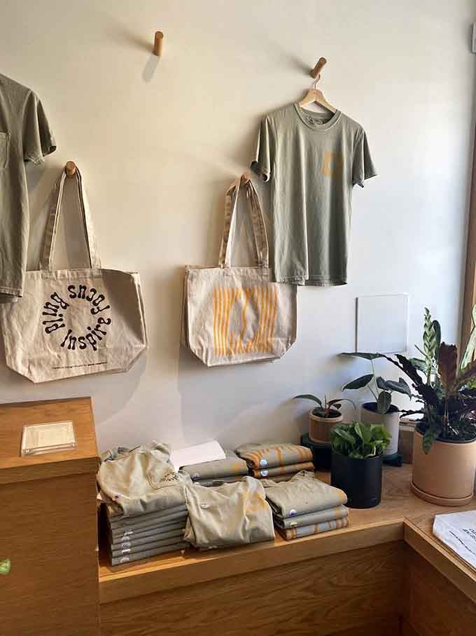 Branded totes and tees hanging like gallery pieces, because supporting local businesses should look this good on you.