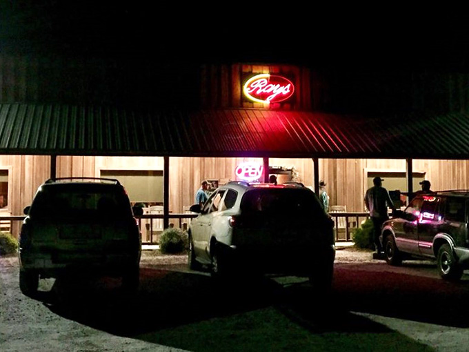 The warm lights spilling onto gravel parking create an irresistible invitation you simply cannot ignore or pass by.