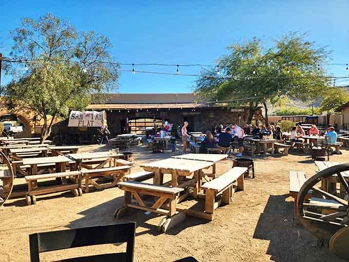 Wooden picnic tables stretch across the desert floor like a massive family reunion where everyone's invited to feast.