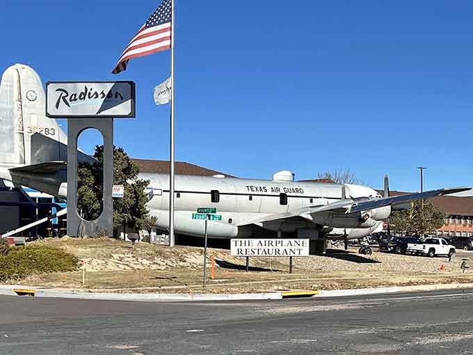 The American flag waves proudly above this grounded aircraft where breakfast, lunch, and aviation history share the same incredible space.