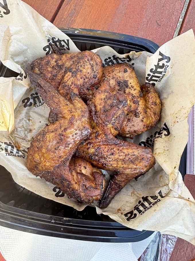 Smoked wings with that deep golden crust show that chicken can absolutely hold its own at a barbecue joint.