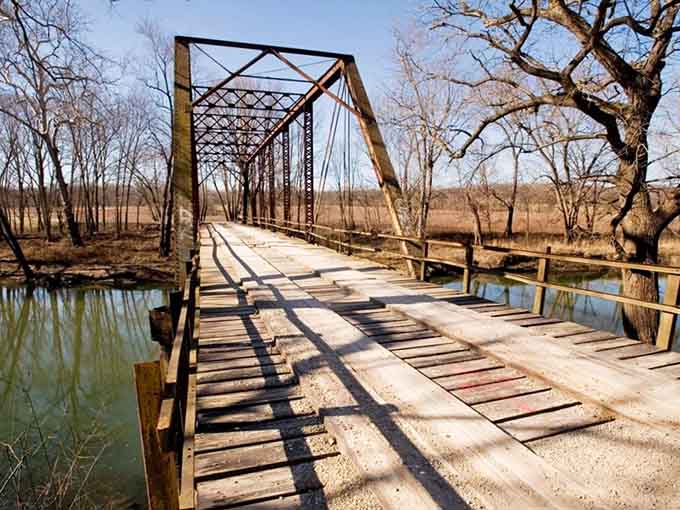 Bare winter branches frame the ironwork like nature's own horror movie set, minus the popcorn and comfortable seating.