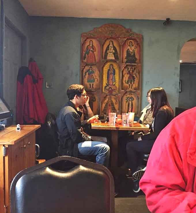 That beautiful carved wooden retablo watching over diners adds spiritual warmth to an already welcoming space filled with conversation.