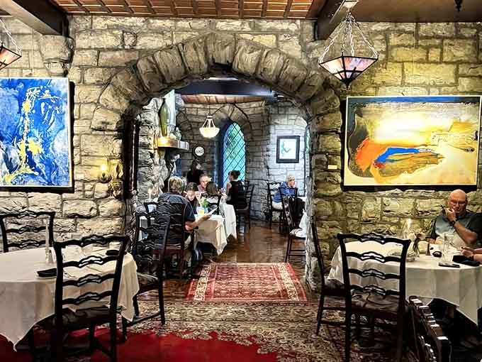 Diners enjoy their meals beneath stone arches while colorful artwork adds unexpected modern flair to medieval surroundings.